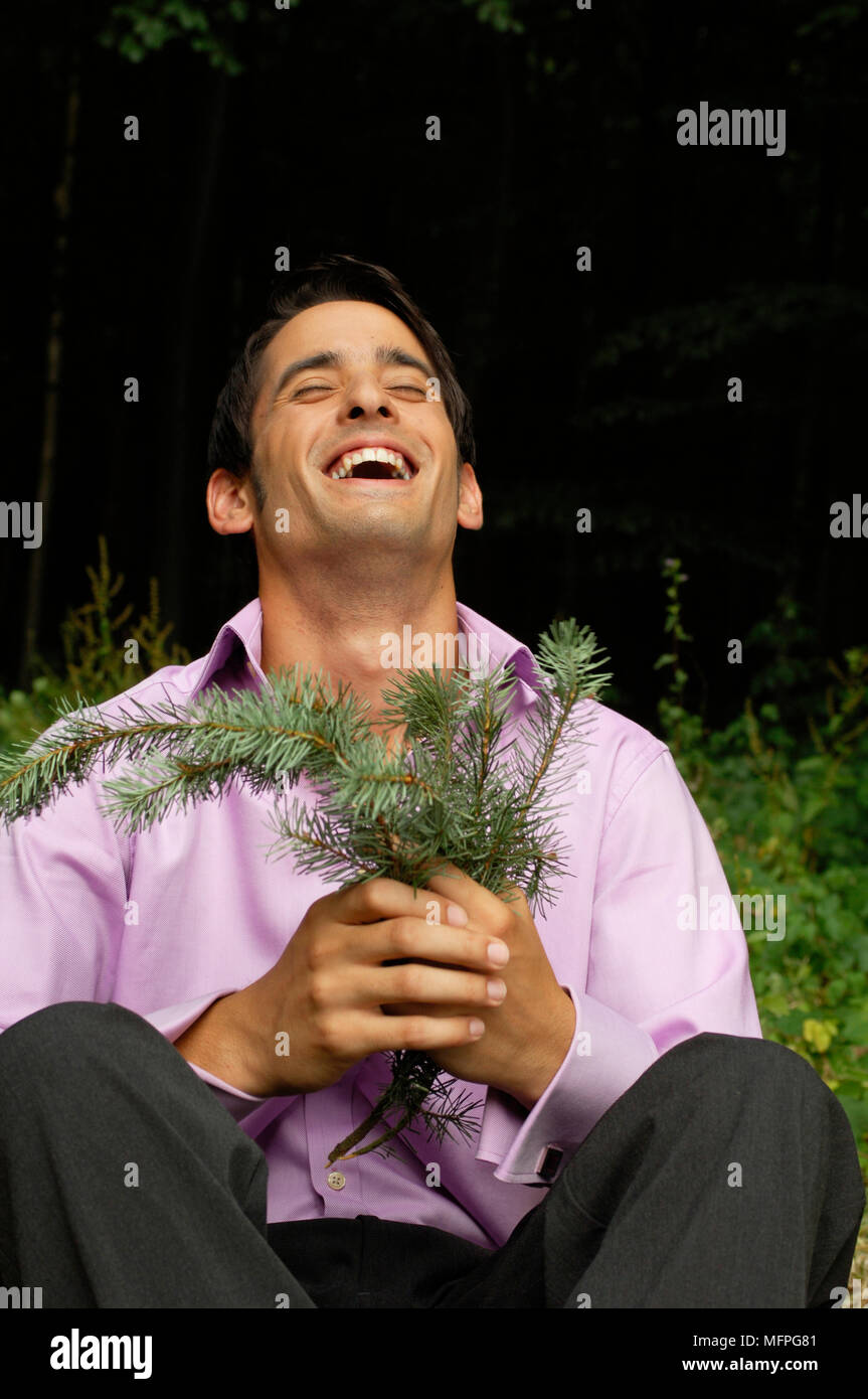 Young man holding a plant and laughing Ref: CRUSC 10015 034 Compulsory ...