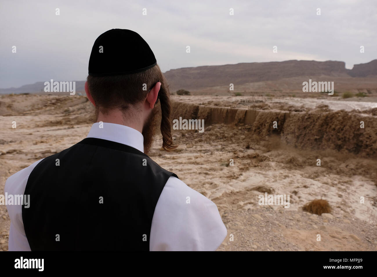 Ultra orthodox Jew gazing at a flooded motorway along the Dead Sea ...