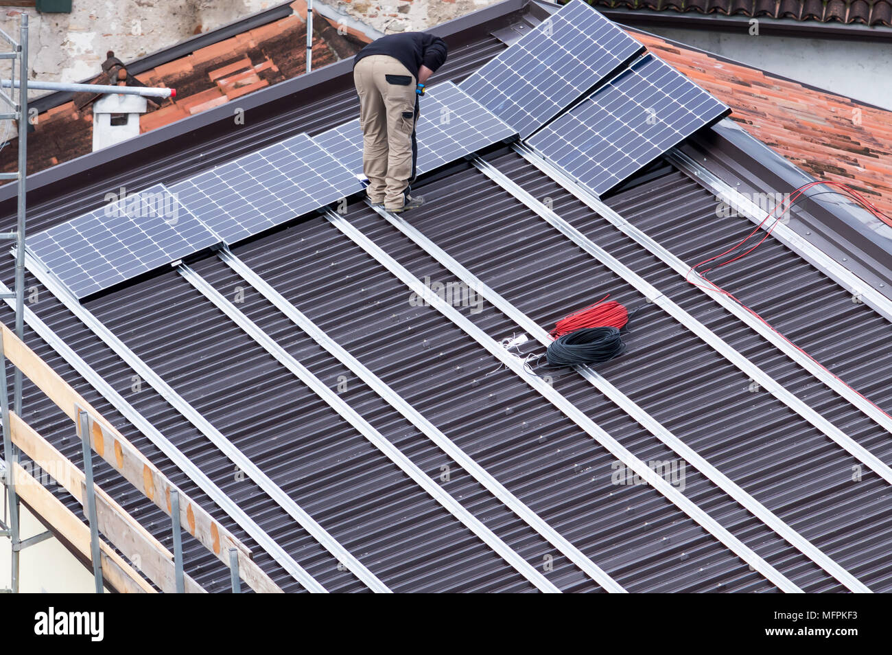 Installation of solar panels on a roof Stock Photo - Alamy