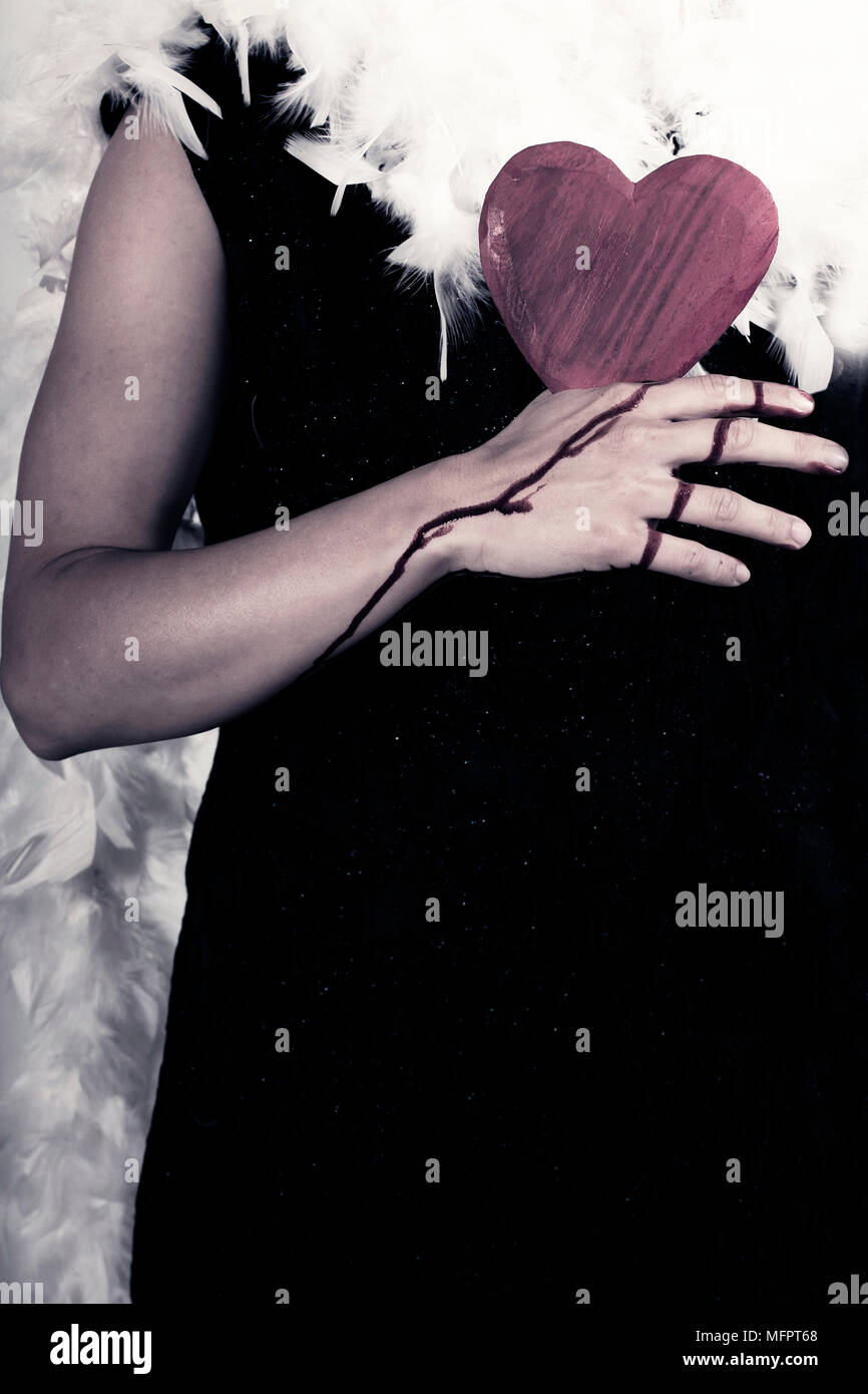 a woman with blood on her hands holding a heart Stock Photo - Alamy