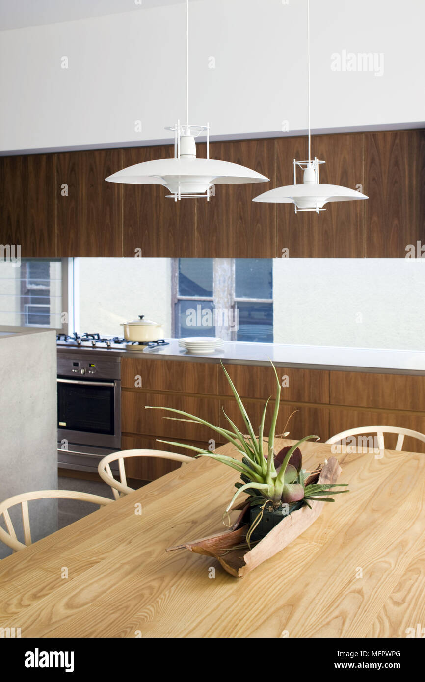 Ceiling lights above wooden table in open plan modern kitchen Stock ...