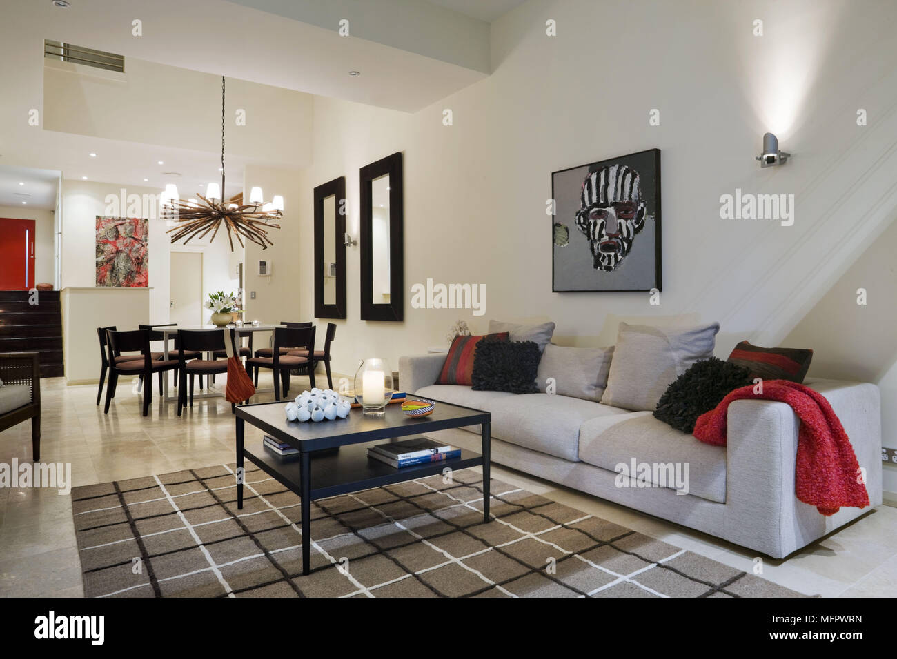 Coffee table in front of upholstered sofa in spacious modern open plan ...