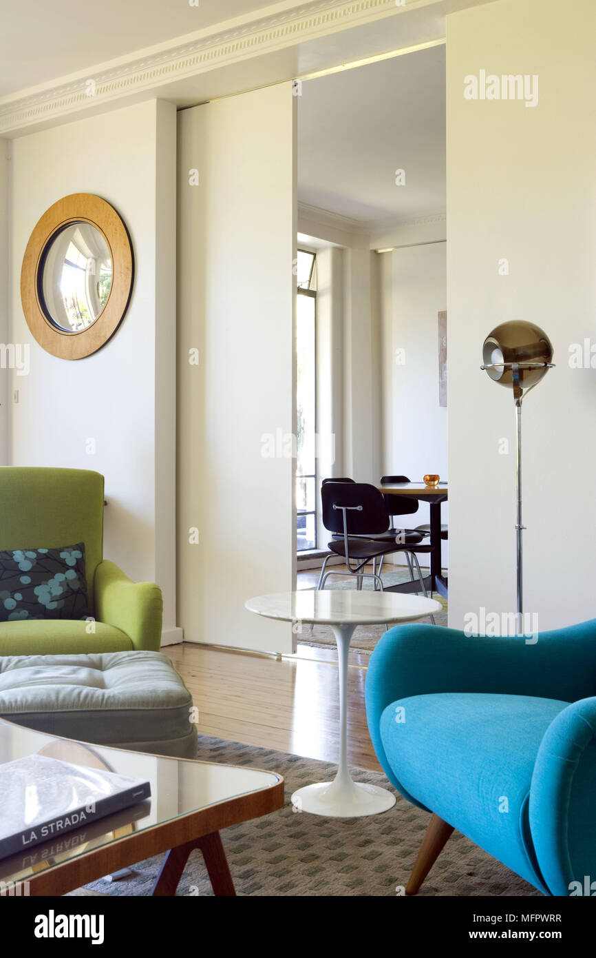 Colourful chairs in modern sitting room with sliding doors giving view ...