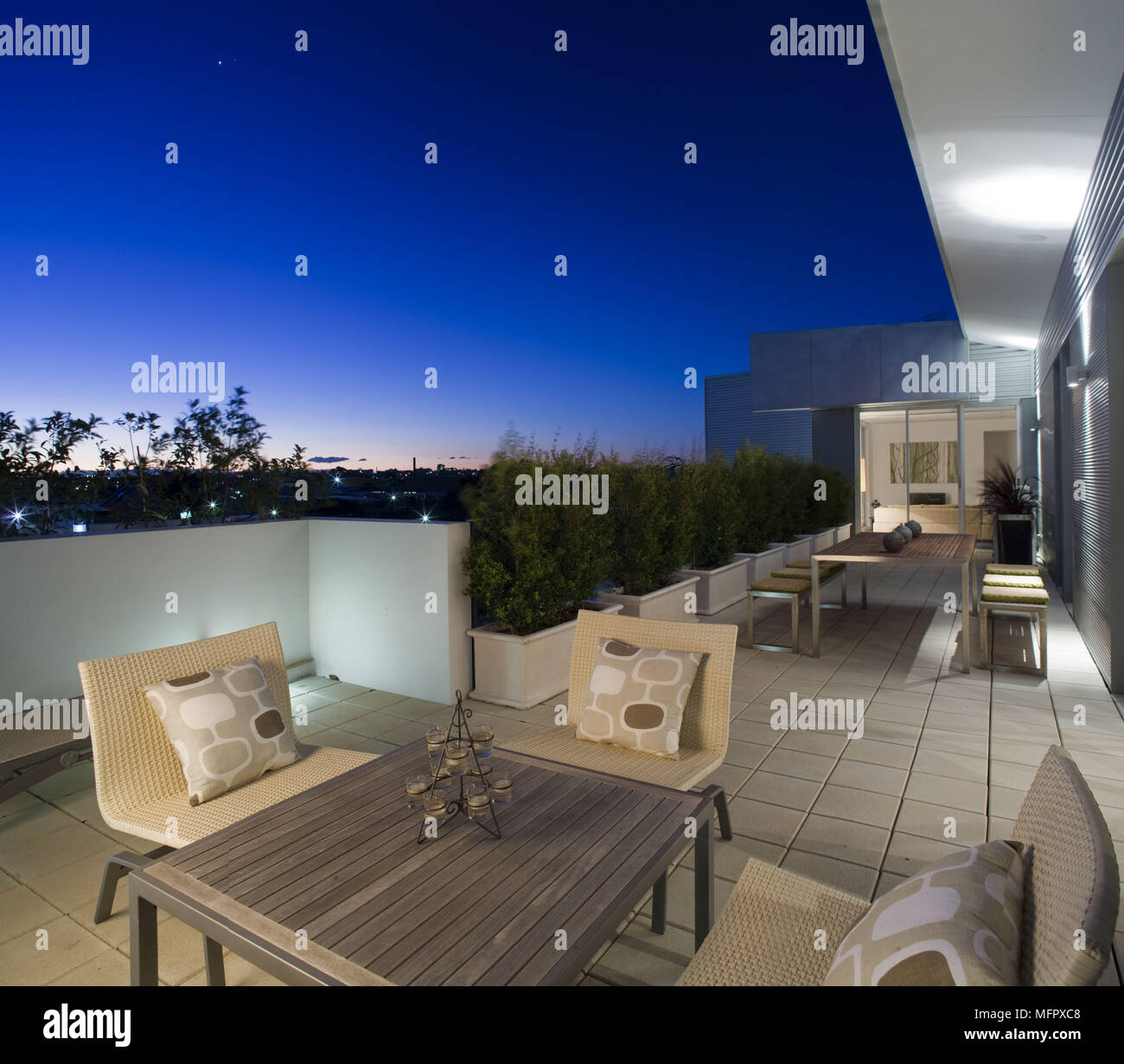 Table and chairs on paved terrace area at night Stock Photo - Alamy