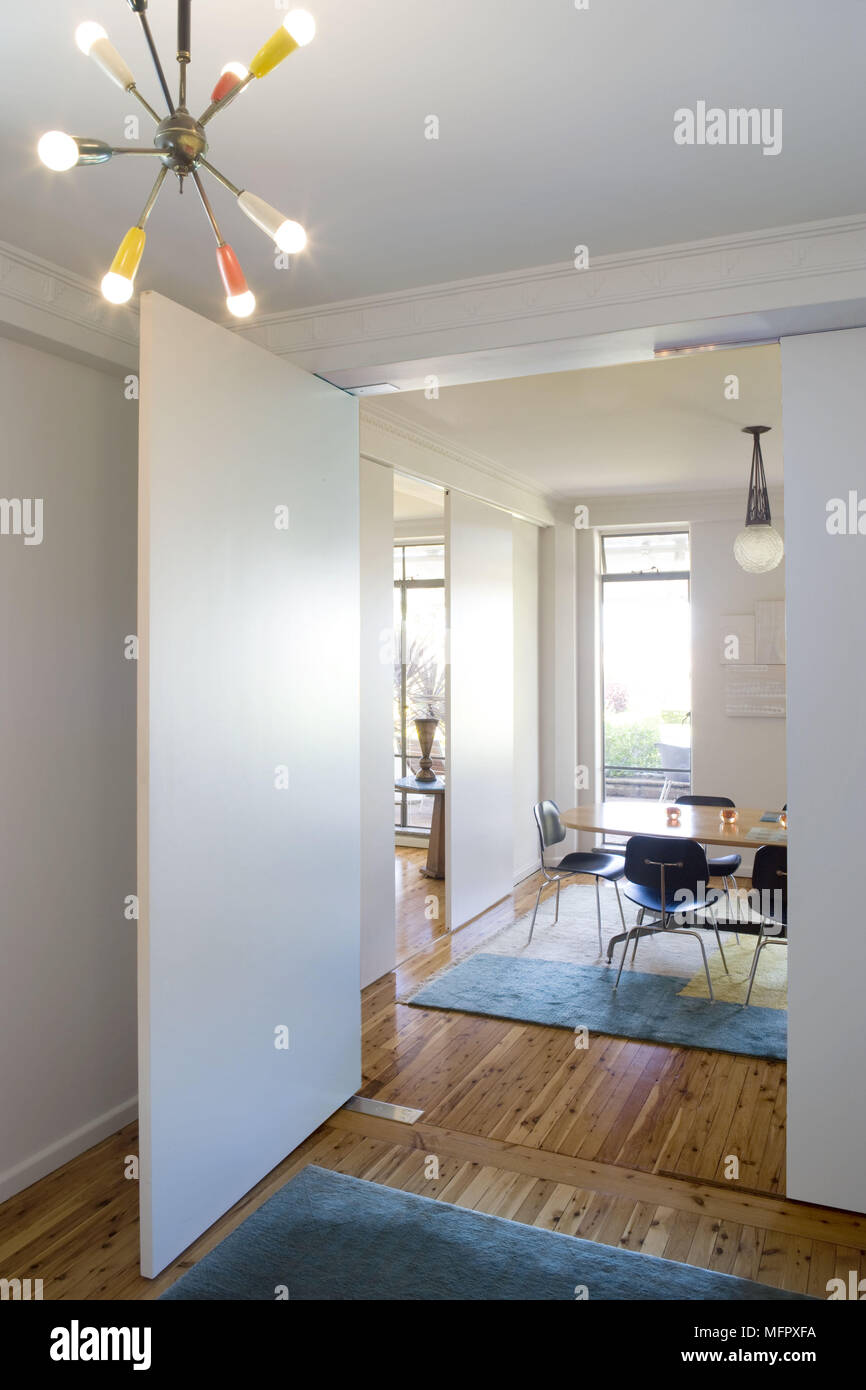 View through open door to retro style table and chairs in modern dining ...