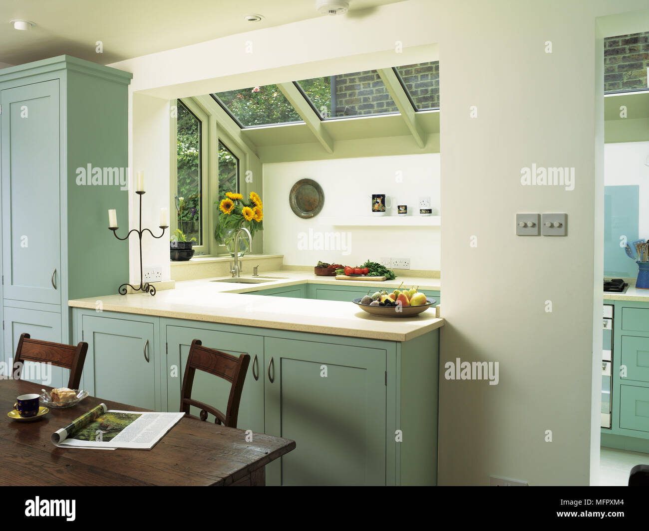 Contemporary kitchen with blue units and glass roof Stock Photo - Alamy