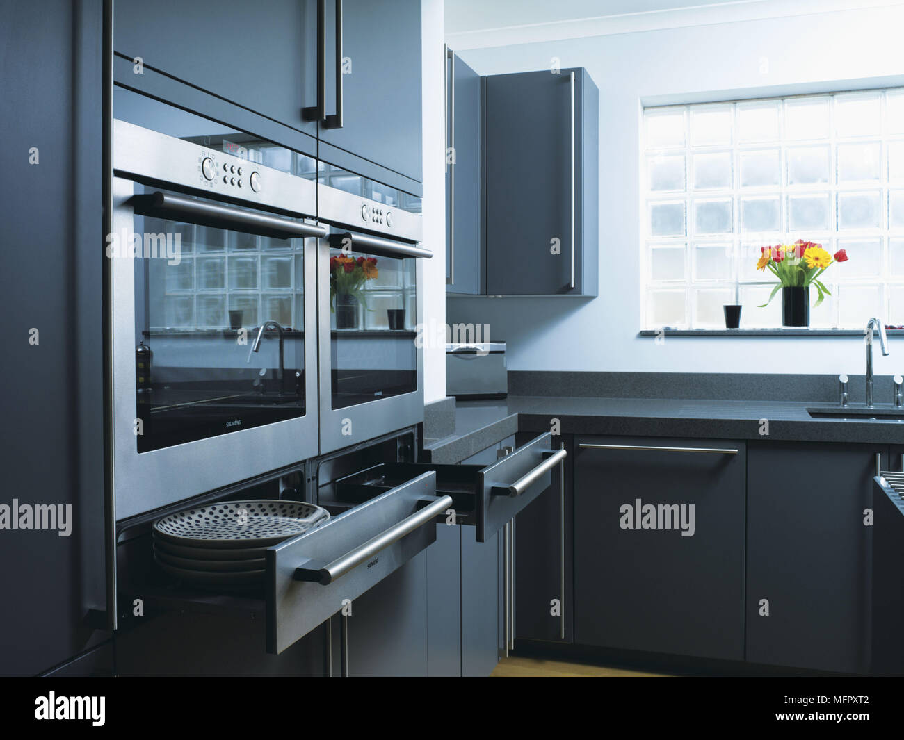 Integral ovens with drawers below in contemporary kitchen Stock Photo ...