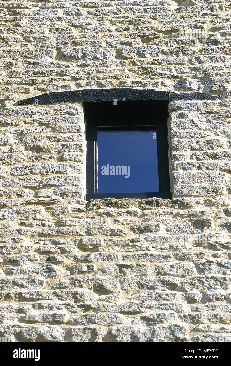 Exterior detail of a small square window in a converted stone barn ...