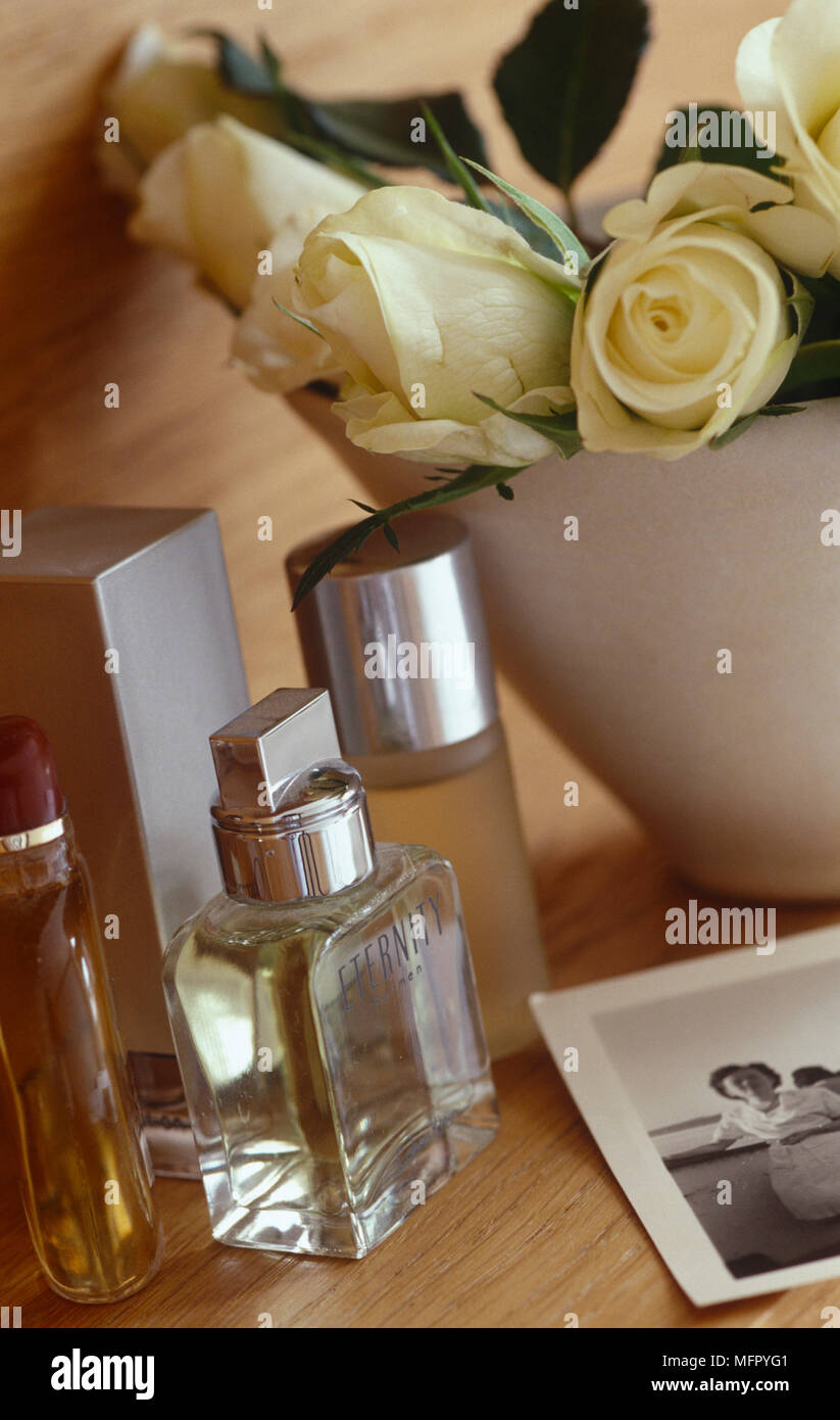 Close up of perfume bottles and yellow roses Stock Photo - Alamy