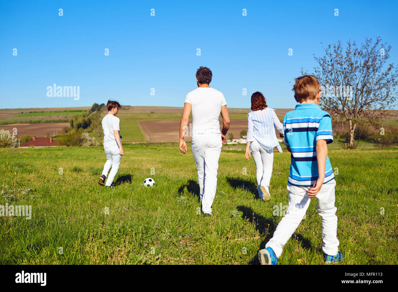 Happy family playing with a ball on nature in spring, summer Stock ...
