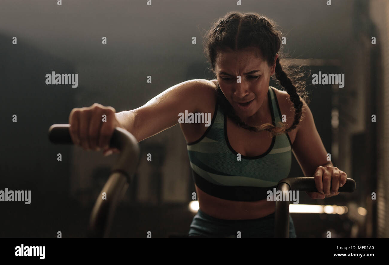 fitness woman on gym bicycle doing exercise. Female putting full effort ...