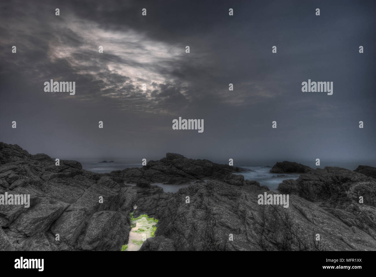 Rocks and sea in the early morning at Cove Bay; a little harbour along ...
