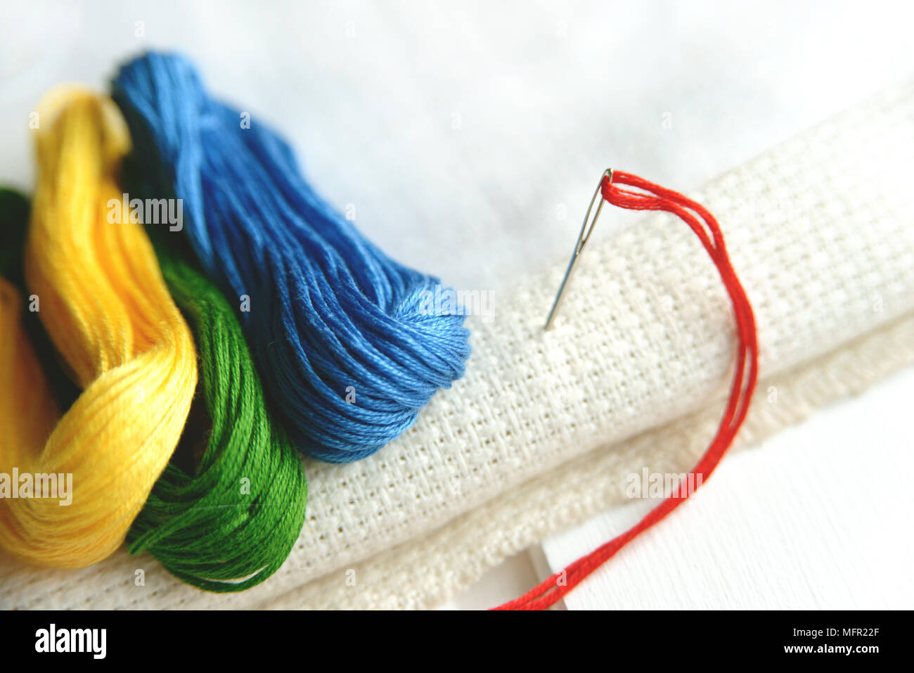 Needle in canvas with threads of different colors for embroidery ...