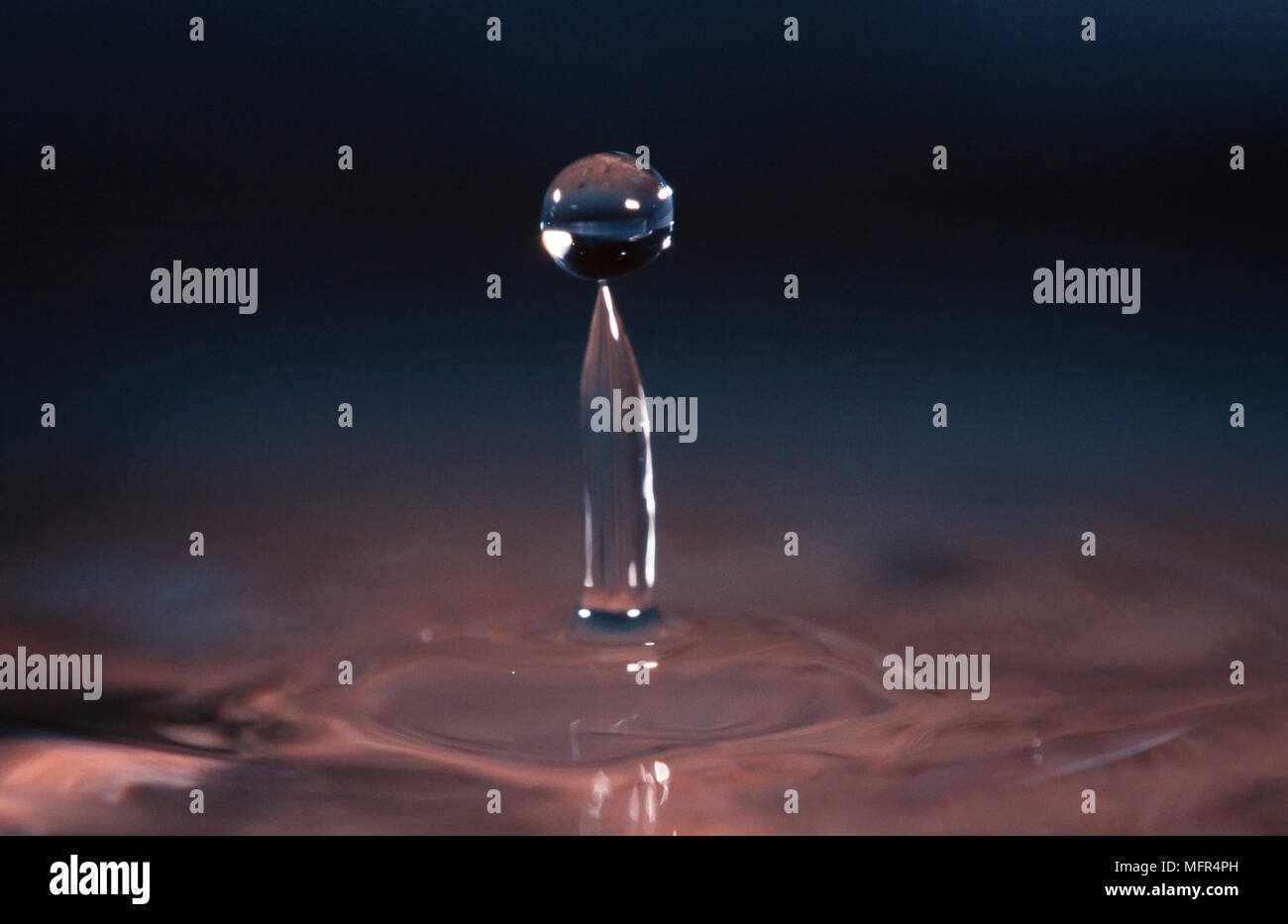 Water drop falling on water surface Stock Photo - Alamy