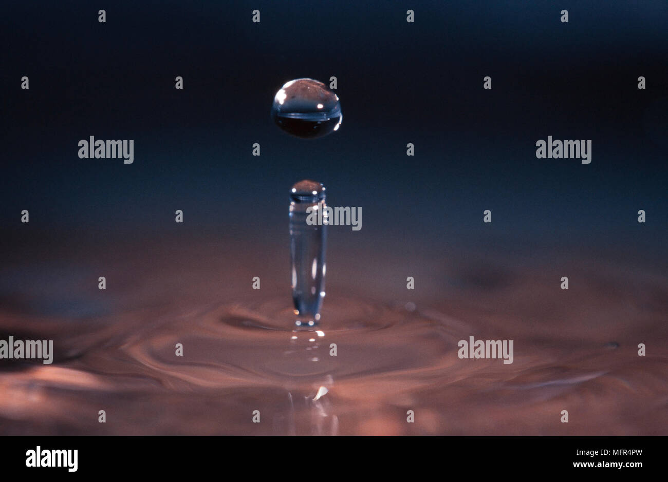 Water drop falling on water surface Stock Photo - Alamy