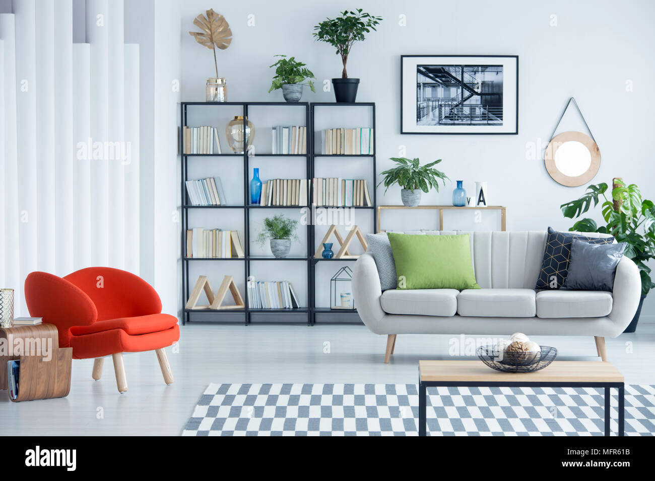 Home library in a bright living room interior with potted plants ...