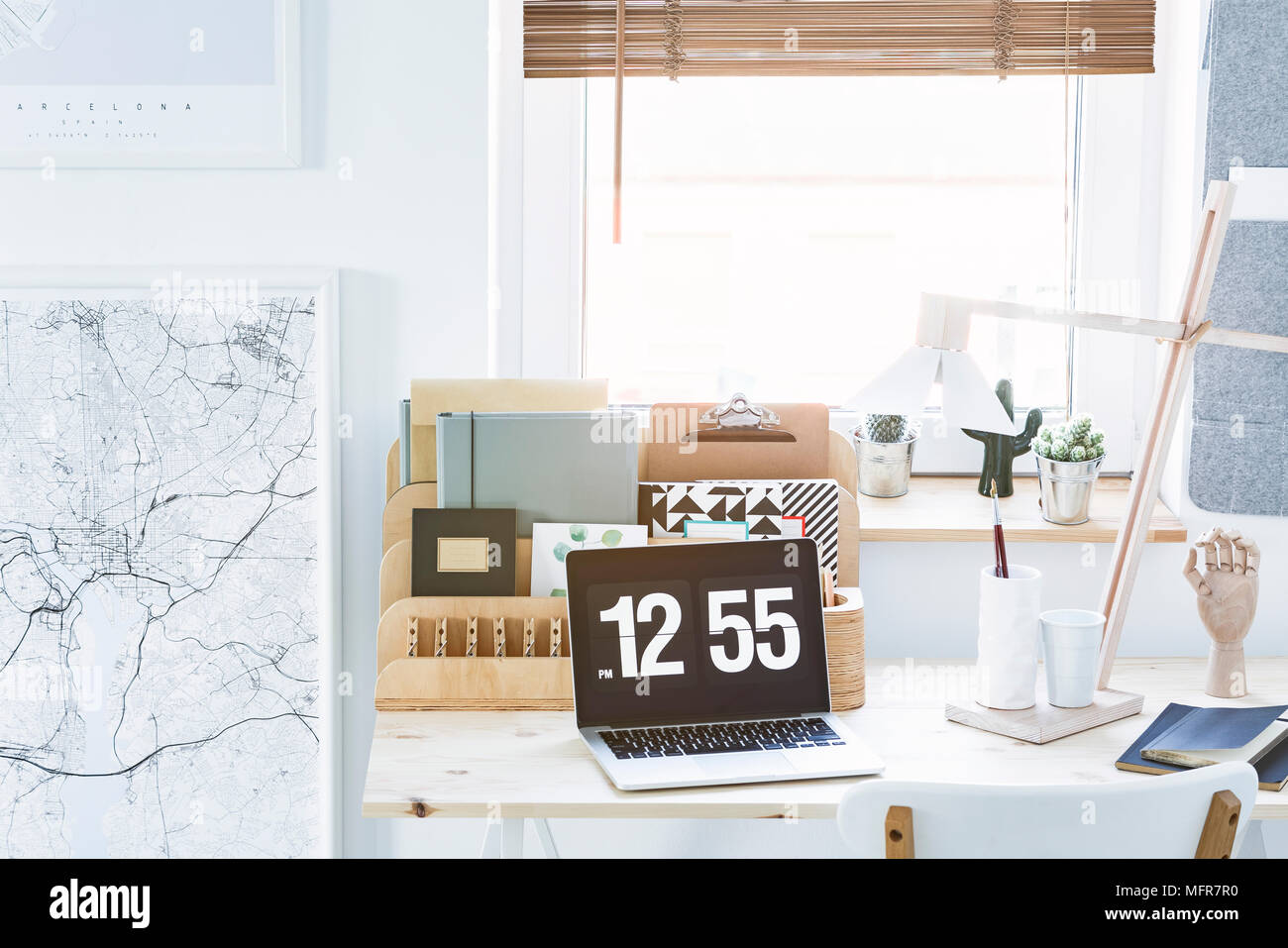 White and black map, wooden desk organizer and laptop with a clock set ...
