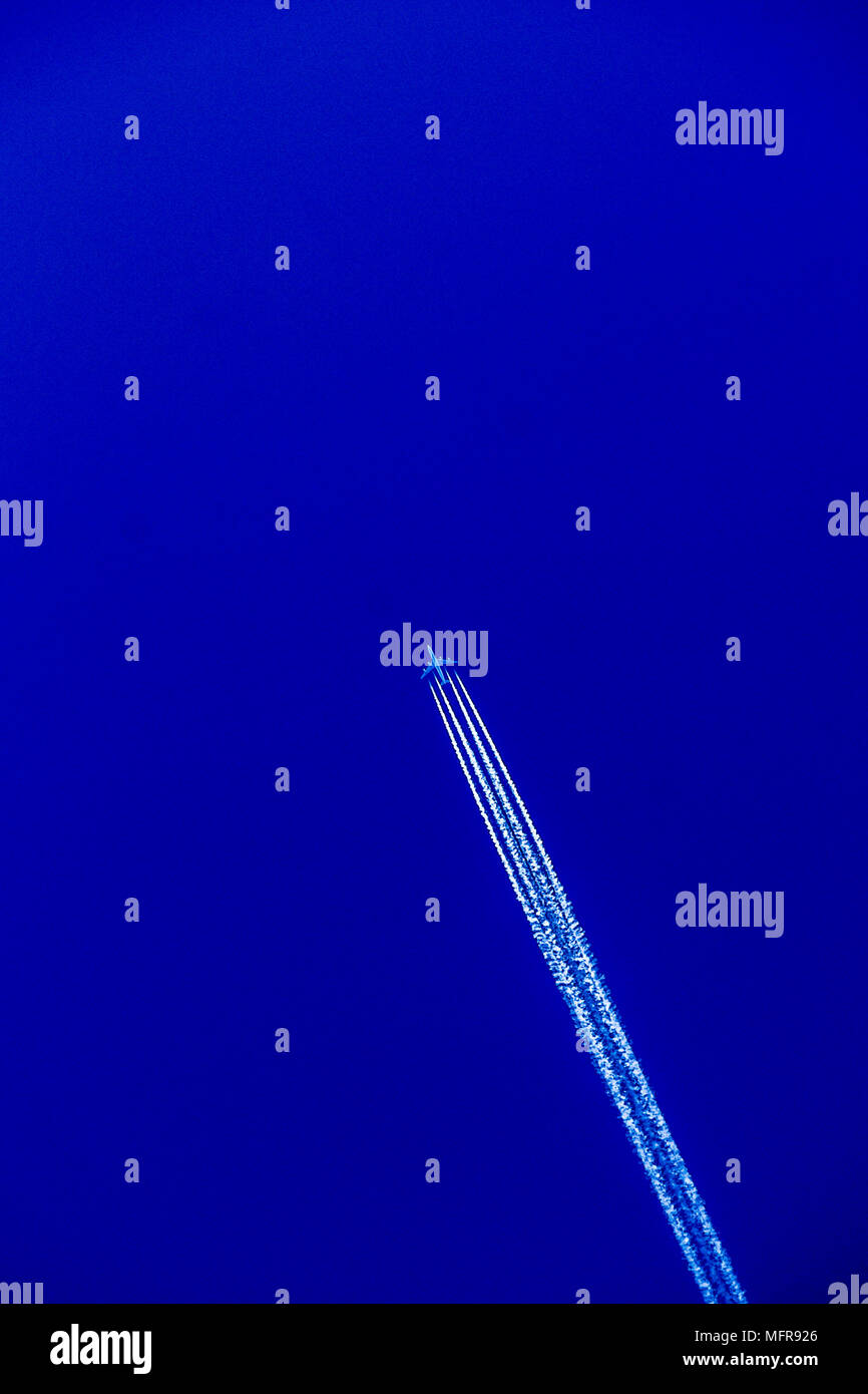 A plane flying across the sky and leaving a trail in the skies Stock ...