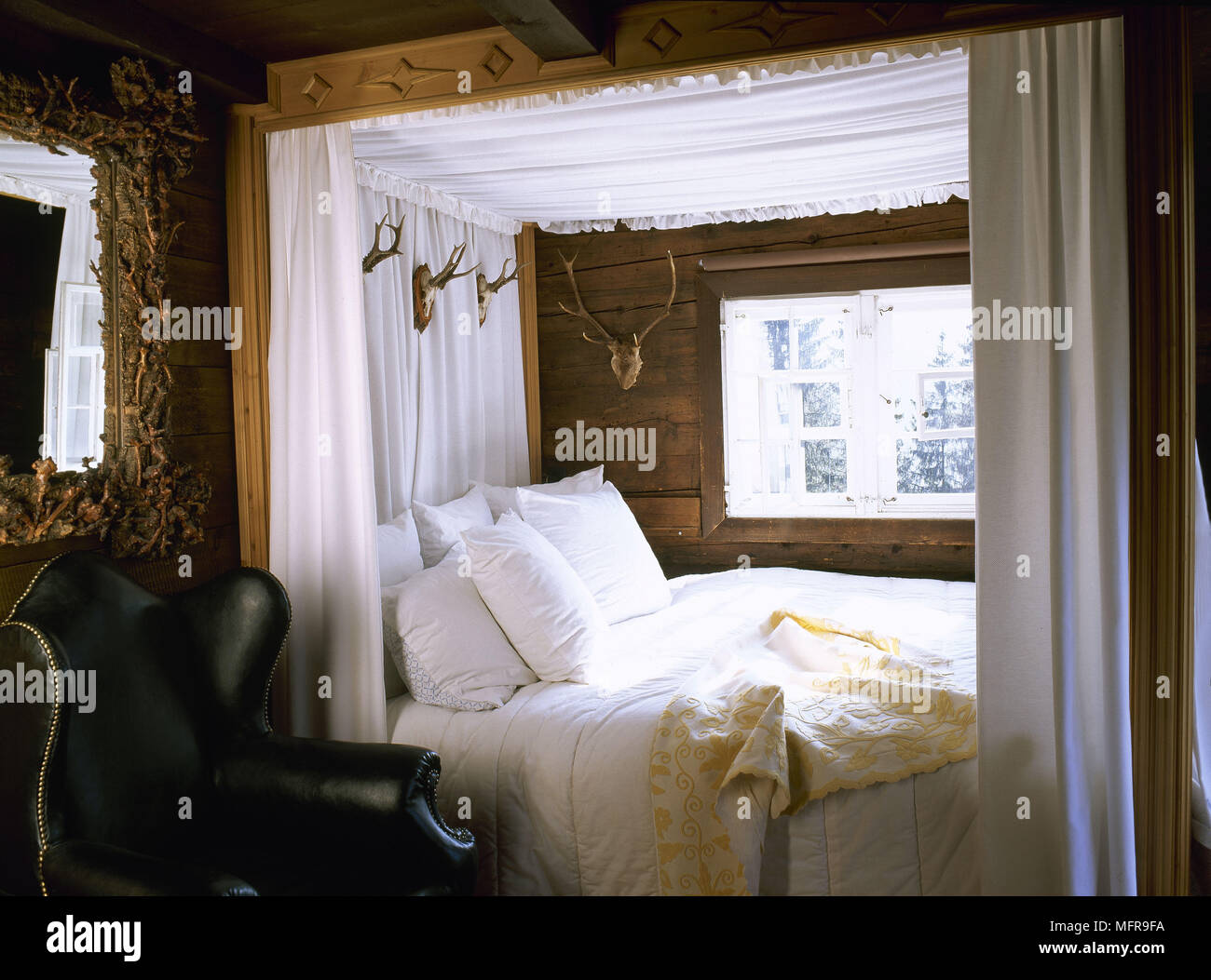 Bedroom with rustic timber walls carved wooden four poster bed with ...