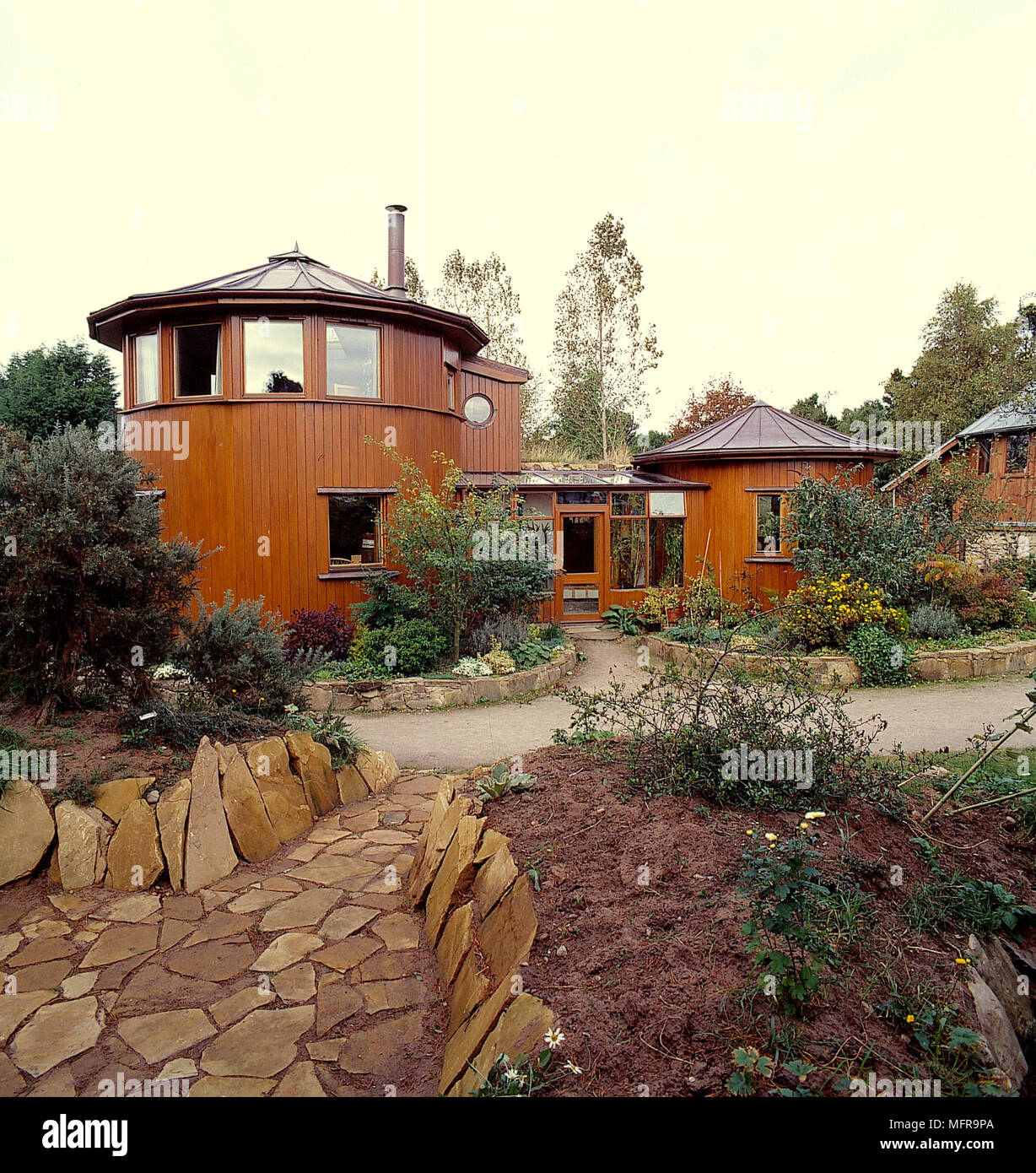 Exterior of new build round timber country house and garden Stock Photo ...