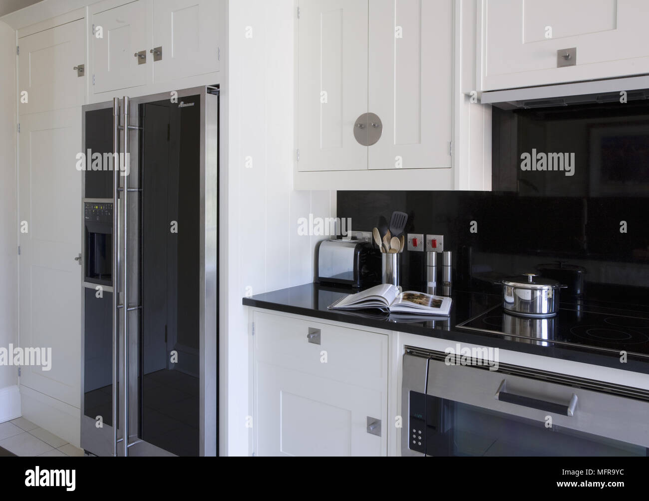 Modern kitchen with integral fridge set in white units Stock Photo - Alamy