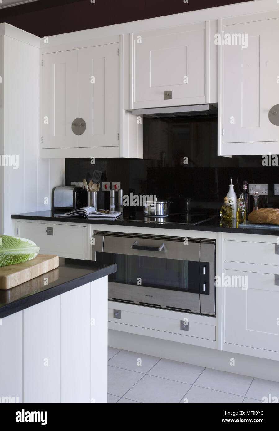 Modern kitchen with integral oven set in white units Stock Photo - Alamy