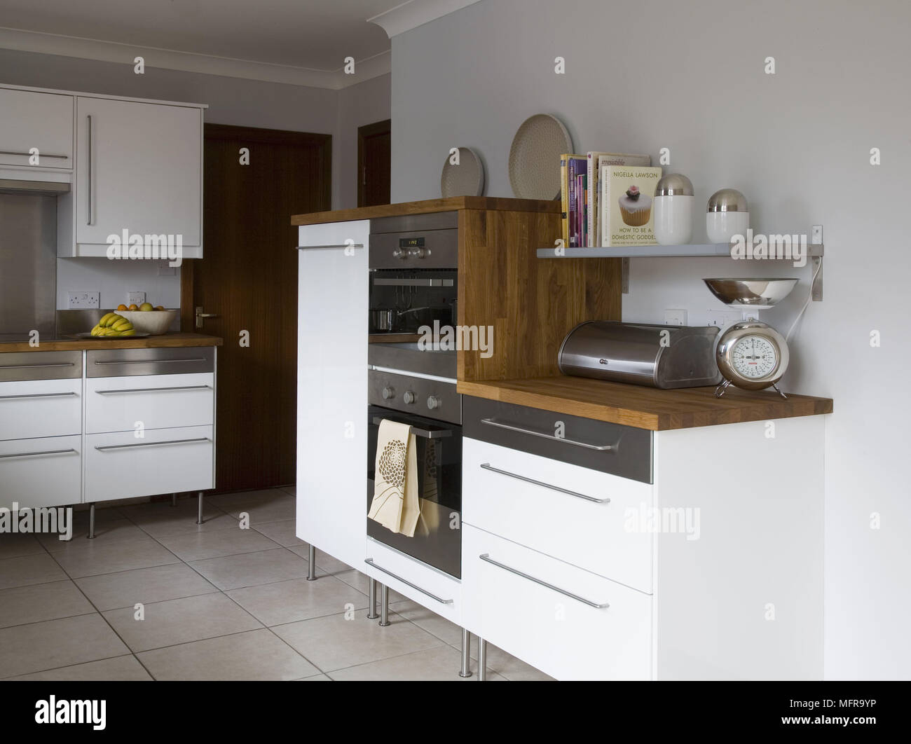 Modern kitchen with integral ovens set in white units Stock Photo - Alamy