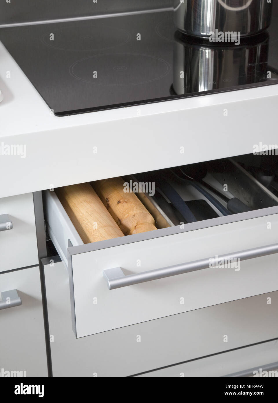 Rolling pins in open drawer of modern white kitchen unit Stock Photo ...