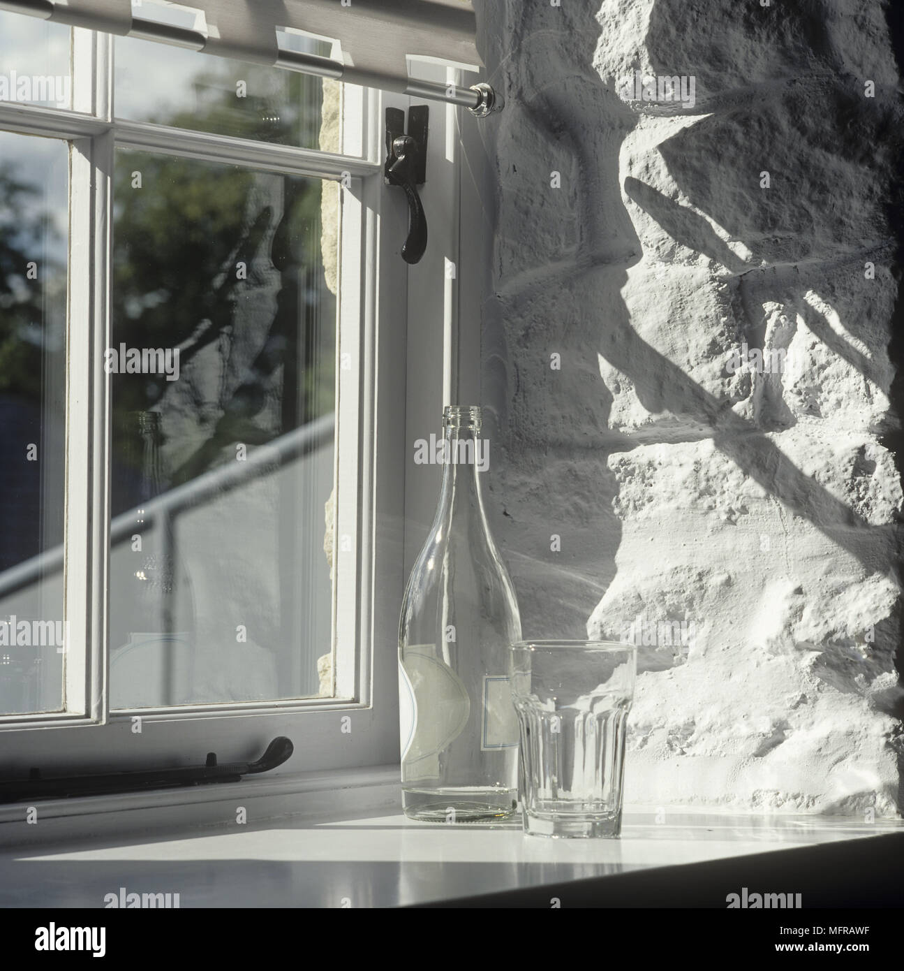 Glass bottle and glass on a sunny window sill Stock Photo - Alamy
