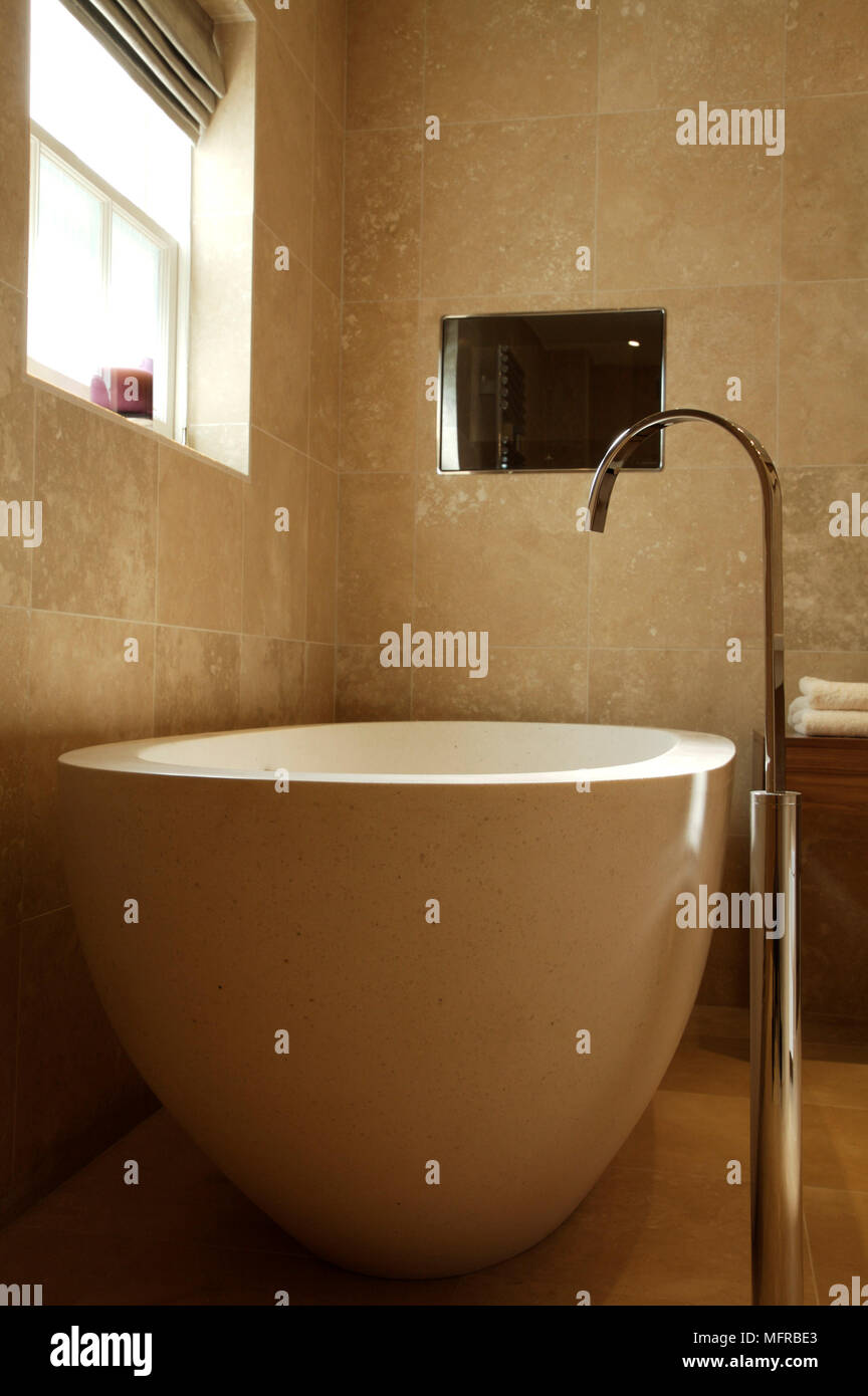 Minimalist oval bath with separate tap Stock Photo - Alamy