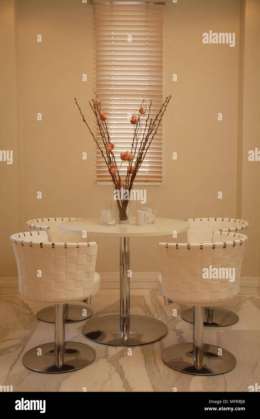 Four circular modern chairs around table with vase of flowers Stock ...