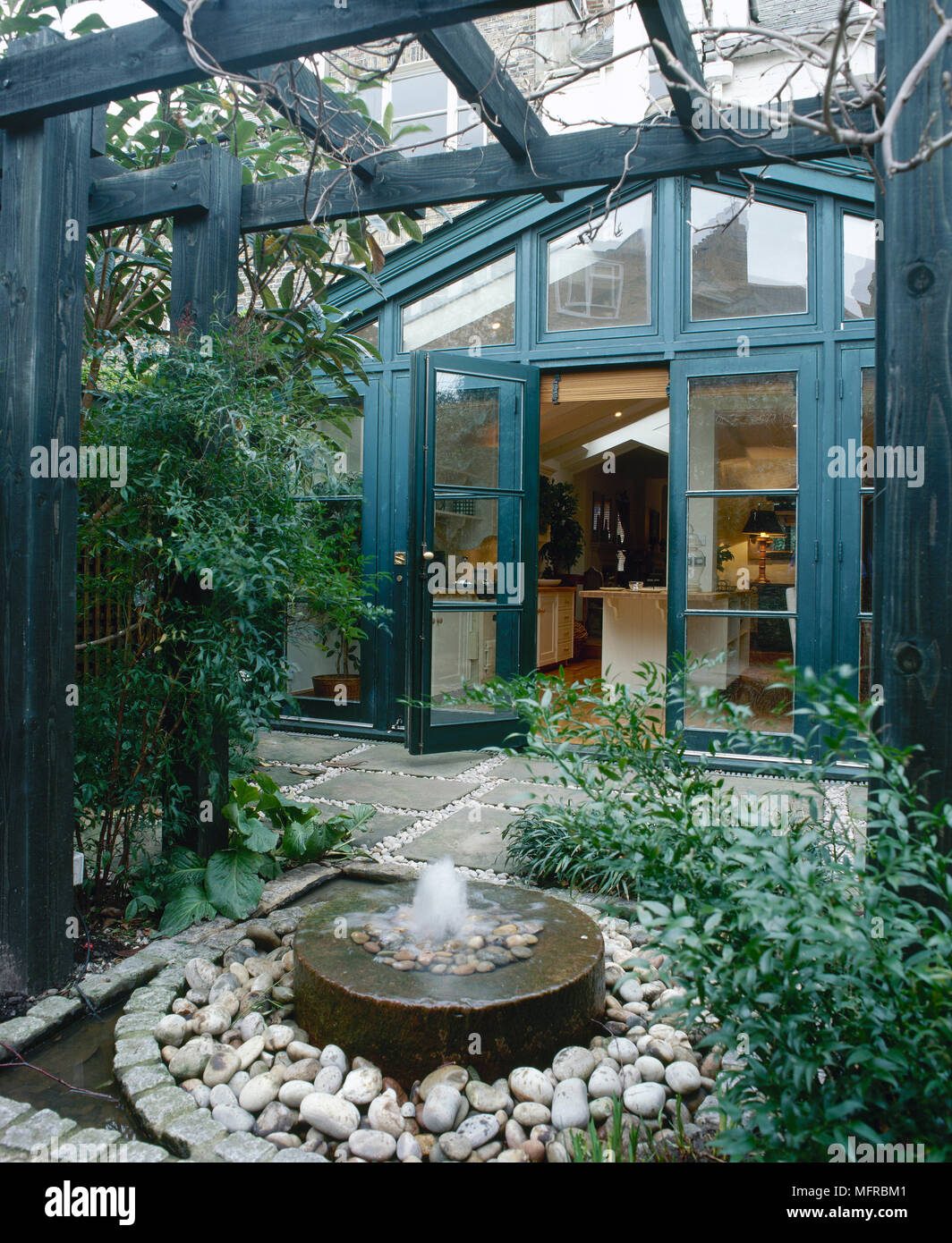 Patio with fountain inside blue painted conservatory Stock Photo - Alamy