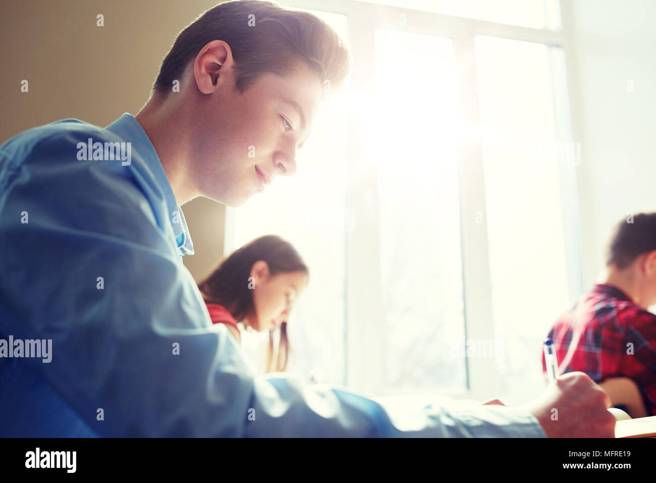group of students with books writing school test Stock Photo - Alamy