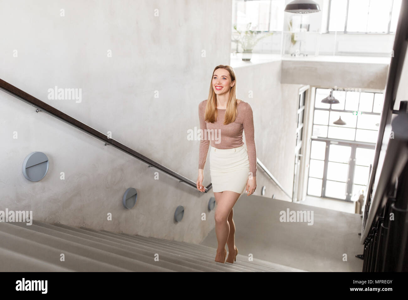 happy smiling woman walking upstairs Stock Photo - Alamy