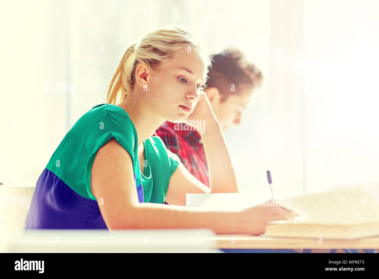 group of students with books writing school test Stock Photo - Alamy