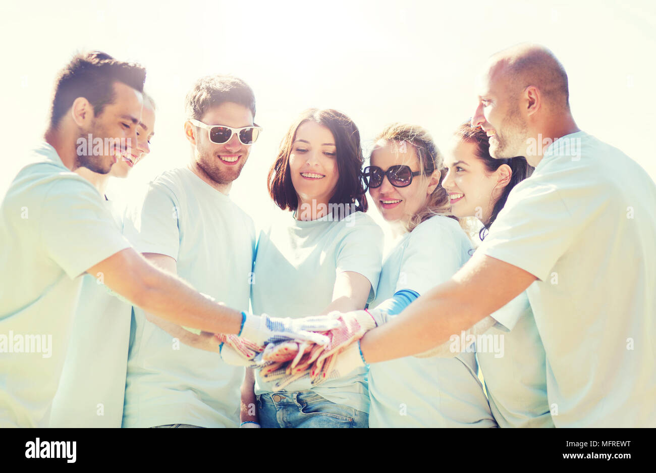 Group volunteers putting hands hi-res stock photography and images - Alamy