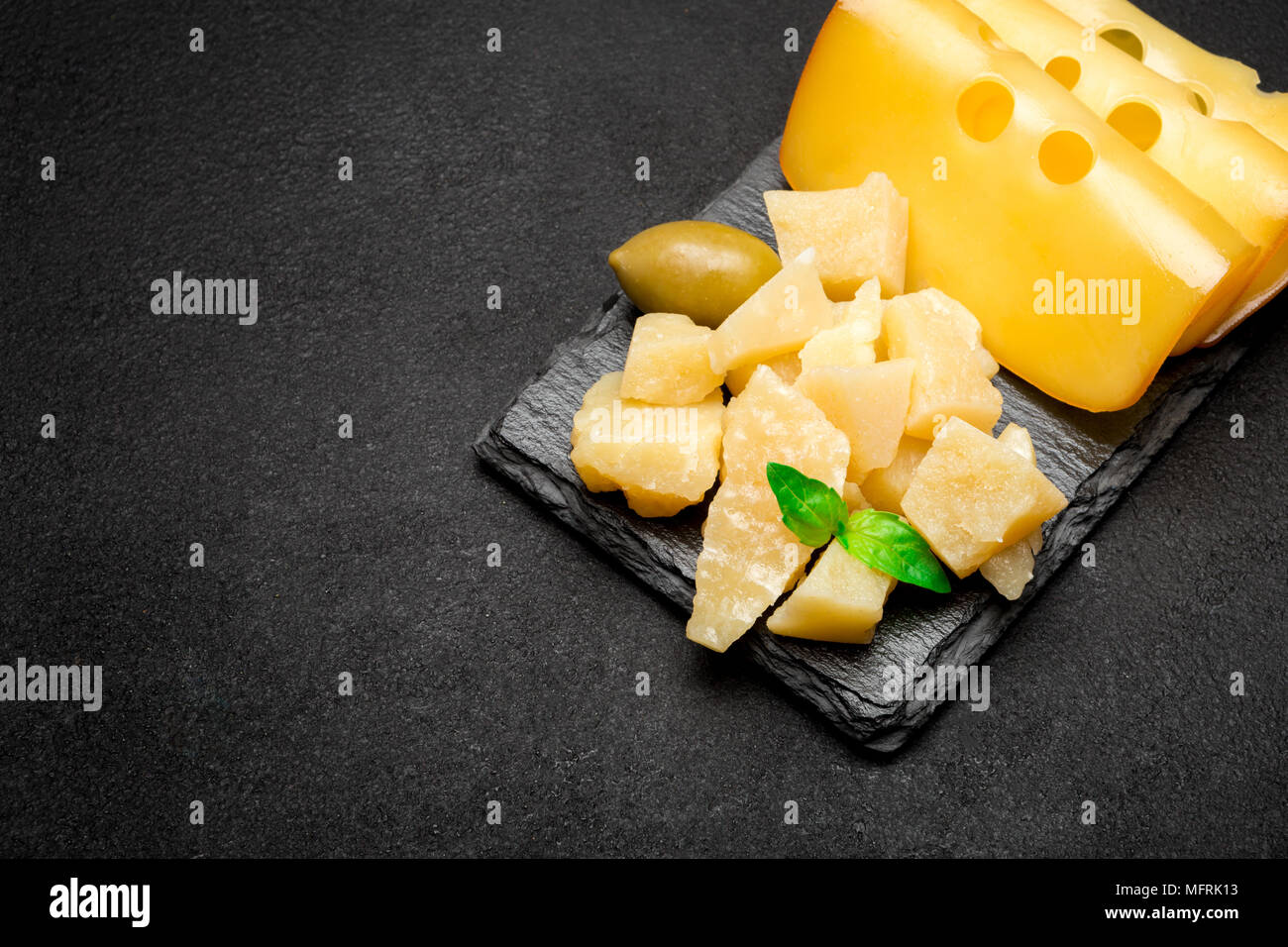 Pieces of parmesan and cheddar cheese on stone serving board Stock ...