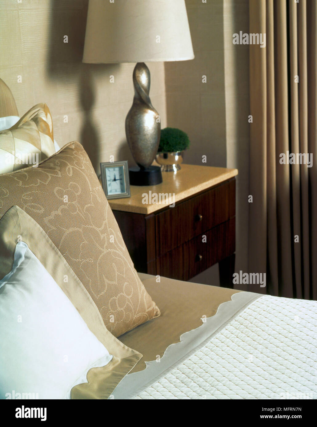 A detail of a modern bedroom double bed dark wood bedside chest of ...