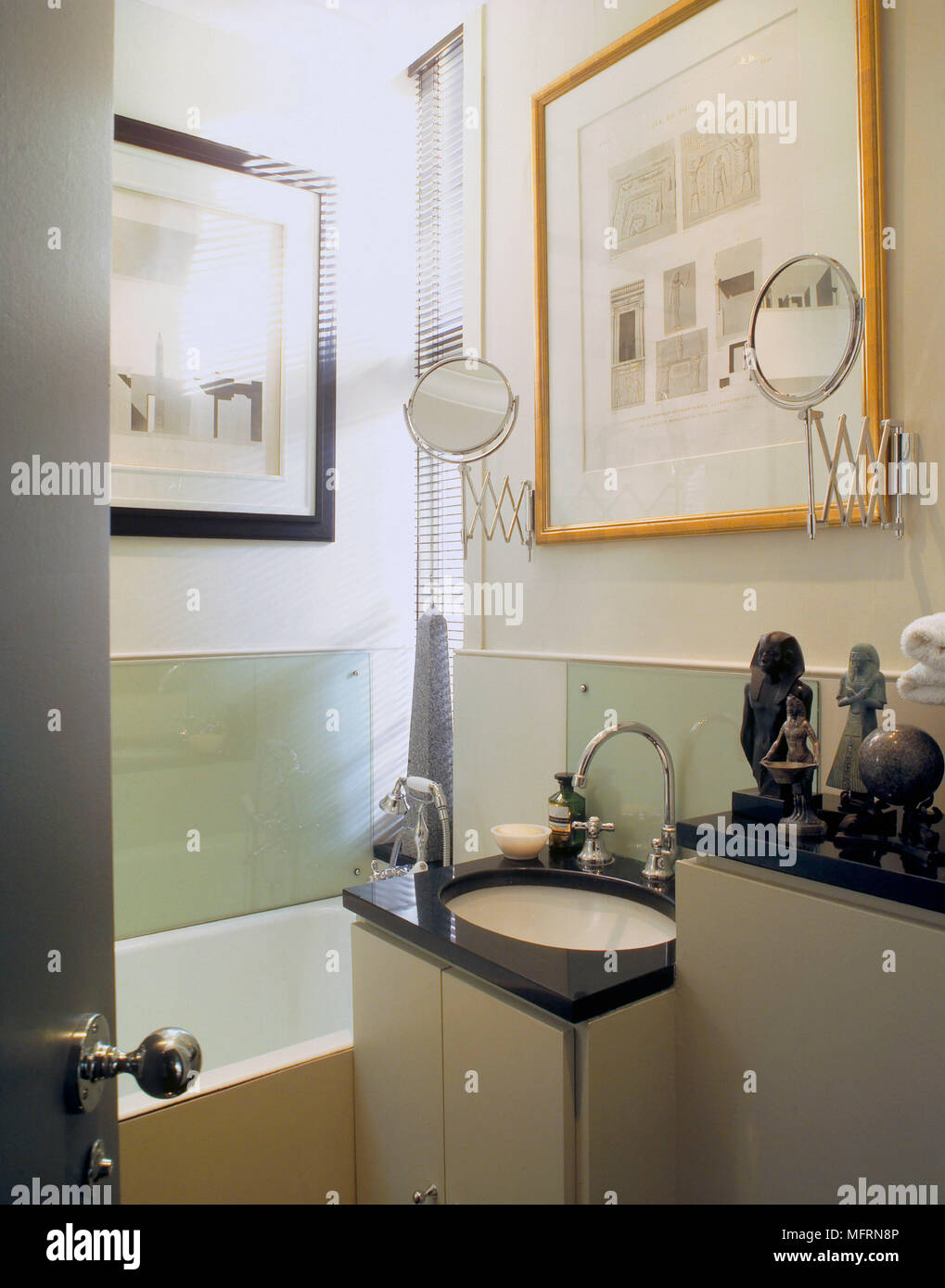 A detail of a modern bathroom wash basin set in cupboard unit perspex ...