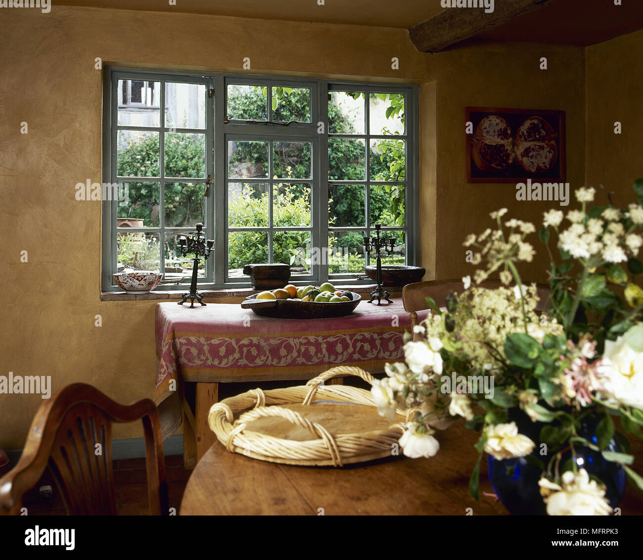 Terracotta dining room with table beneath window Stock Photo - Alamy