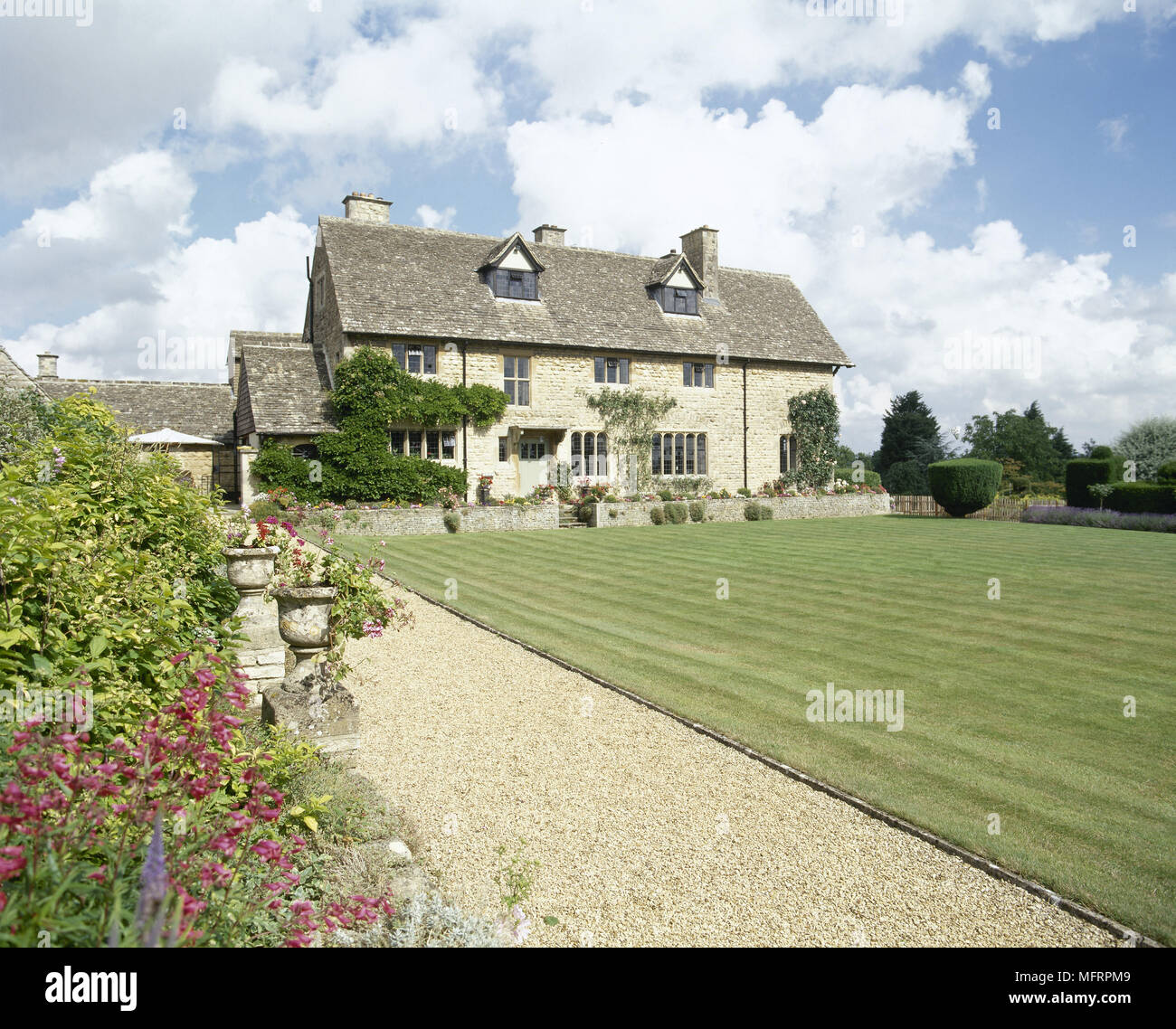Exterior view of a stone country house with a gravel pathway and ...