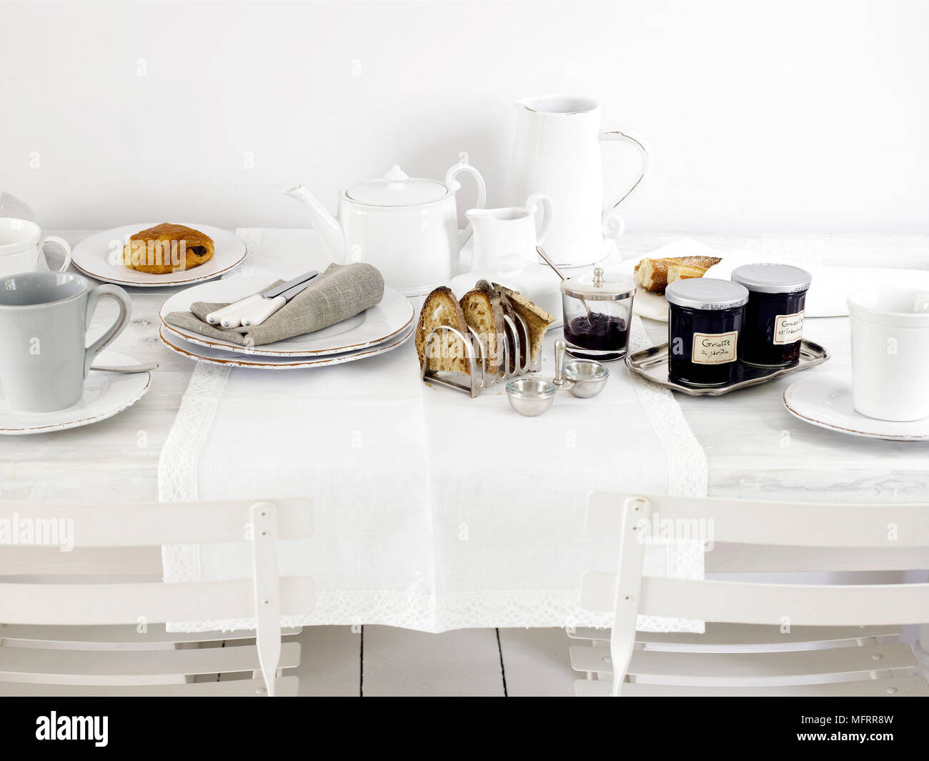 Breakfast items laid out on table with white cloth Stock Photo - Alamy