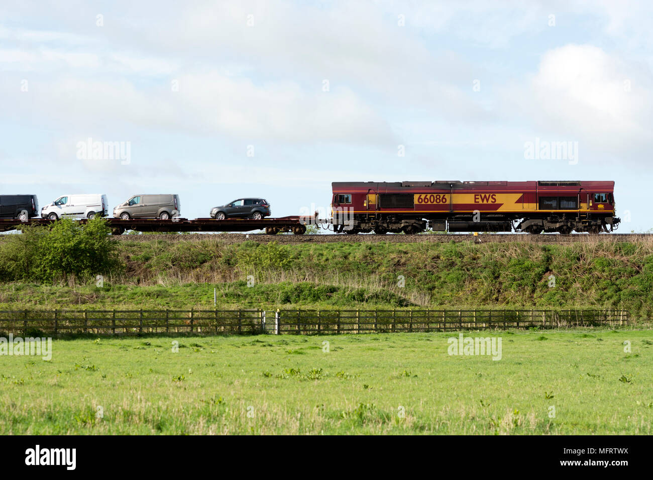 An EWS Class 66 diesel locomotive pulling a Ford car train, side view ...