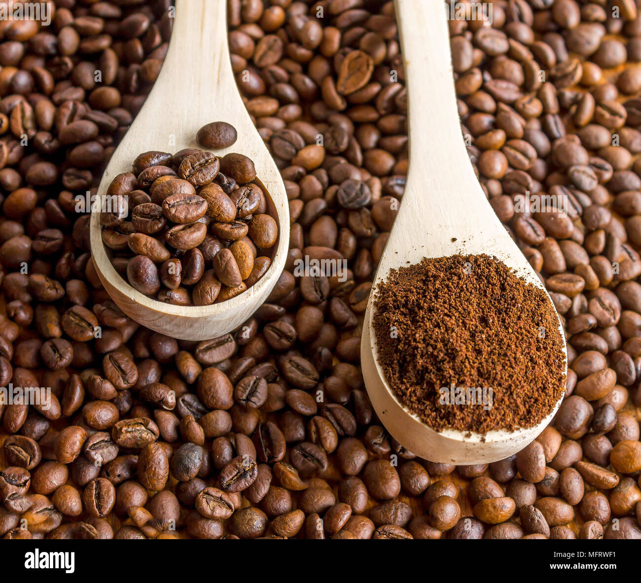 Two wooden spoons with coffee beans and ground coffee Stock Photo - Alamy