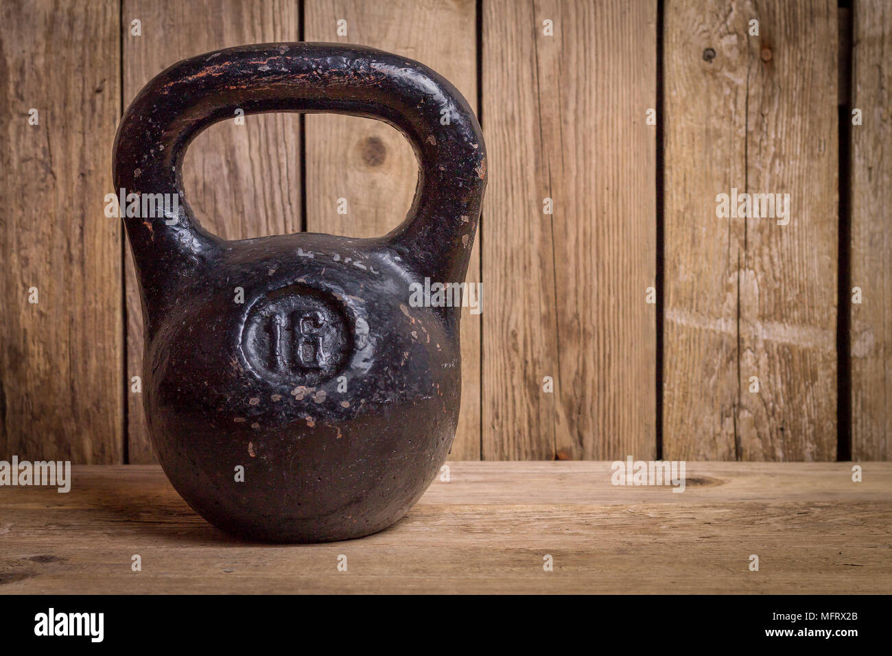 Old kettlebell on wooden deck. Sport background Stock Photo - Alamy