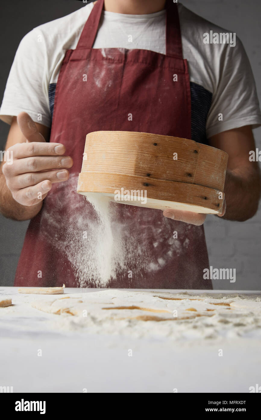 cropped image of chef sifting flour with sieve Stock Photo - Alamy