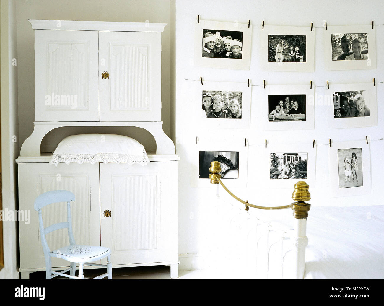 Collection of family photographs next to cupboard in recess in neutral ...