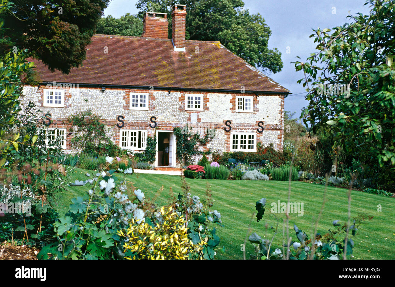 Exterior Of 18th Century Cottage In Sussex Garden With Lawn And Shrubs Exteriors Houses Stone