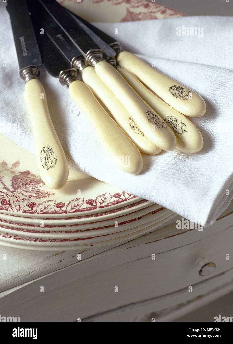 Ivory-handled cutlery white napkins red and cream leaf pattern plates ...