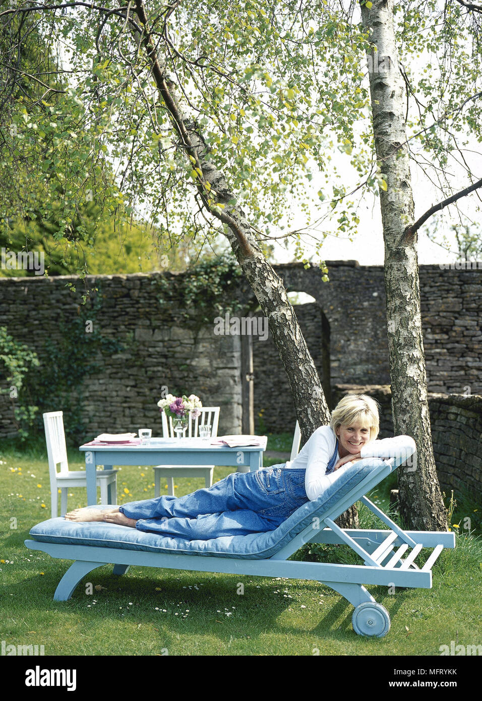 Lena Proudlock on sunbed in the garden painted blue table and white ...